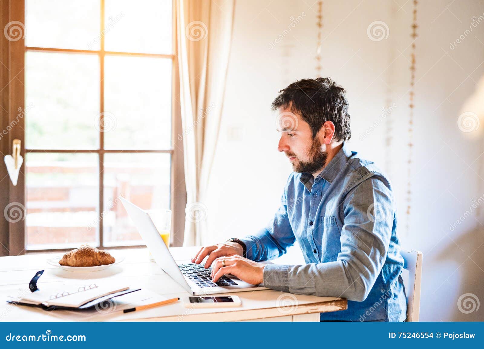 Man Sitting at Desk Working from Home on Laptop Stock Photo - Image of ...