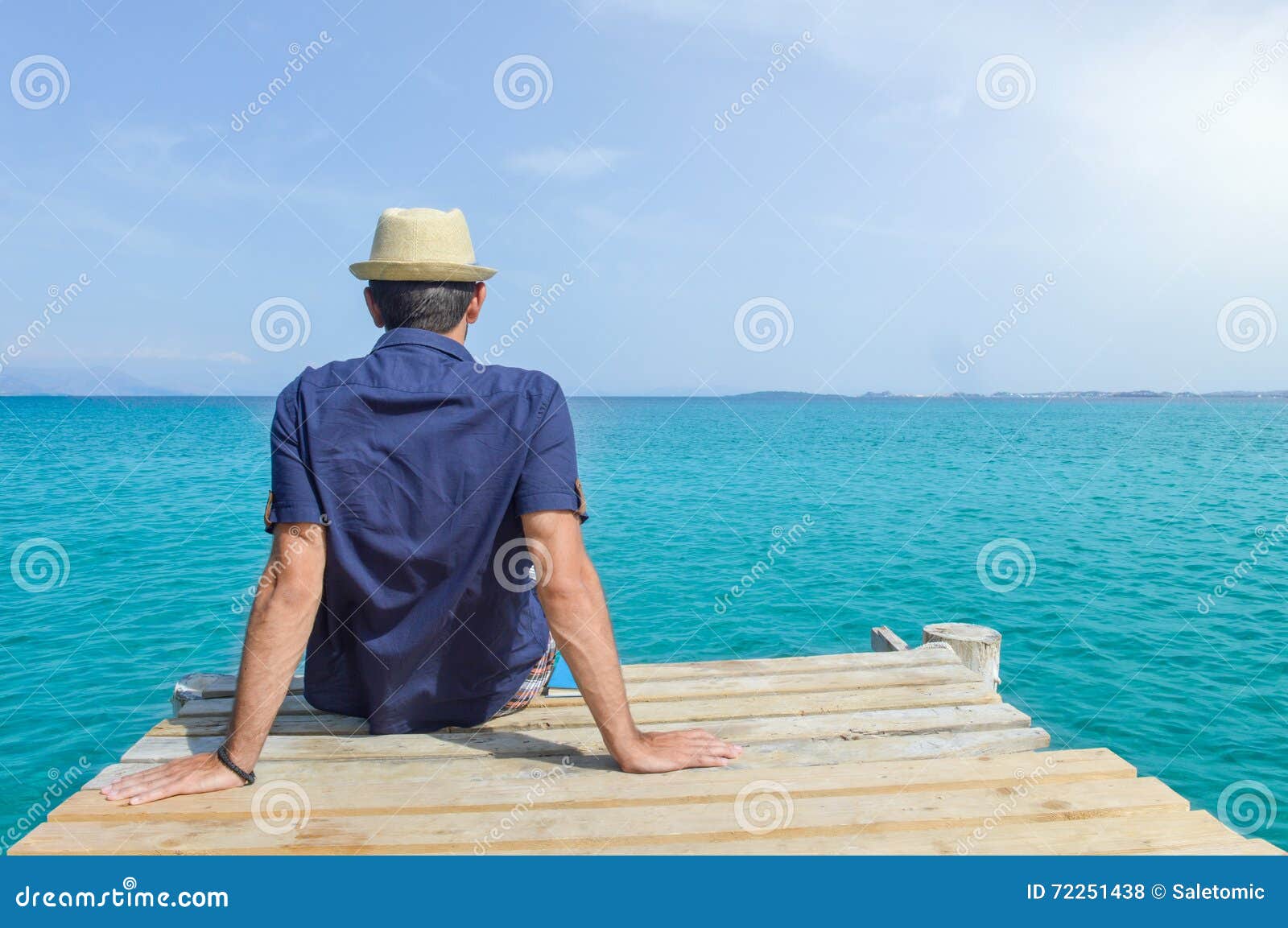 Man Sitting on a Dock at Seaside Stock Photo - Image of straw, sitting ...