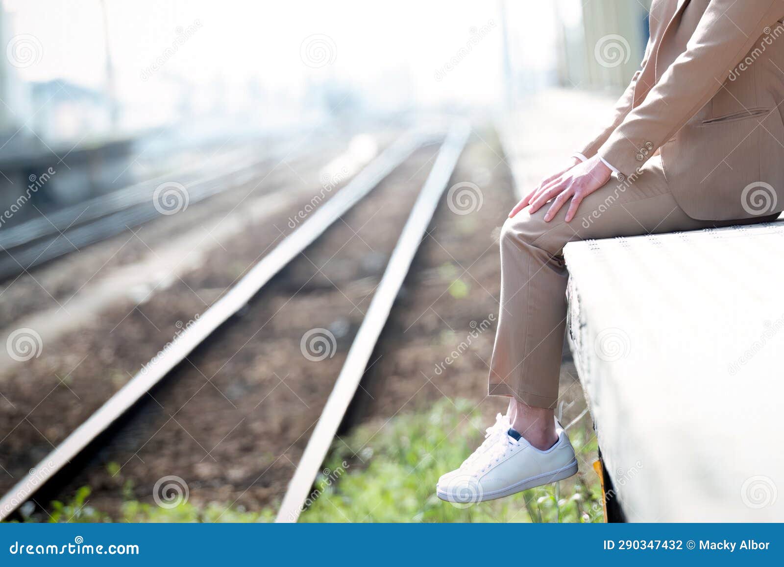 A Man Sitting on the Edge of the Train Platform with Copy Space for ...