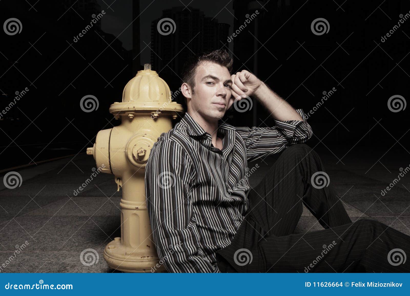 Man Sitting by a Fire Hydrant Stock Photo - Image of yellow, darkness ...