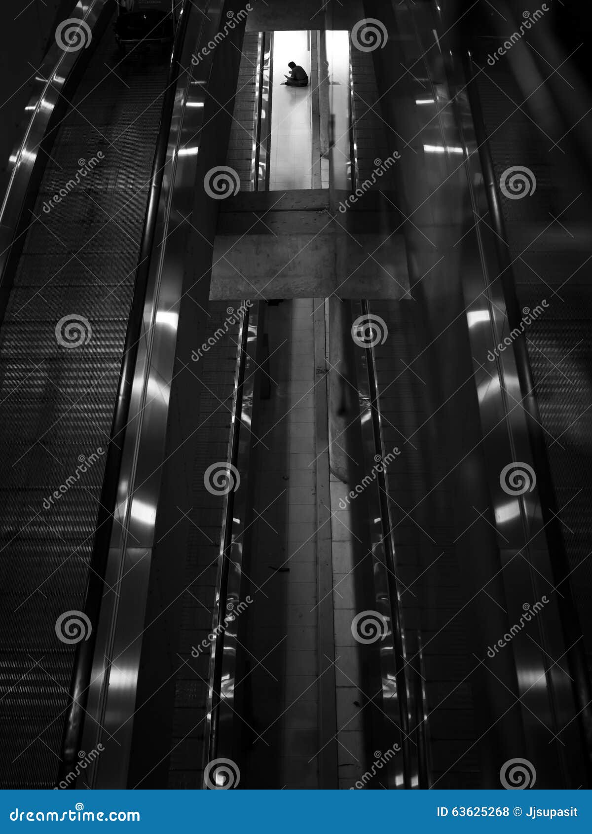 Man Sitting on Floor Under Escalator Stock Photo - Image of escalator ...