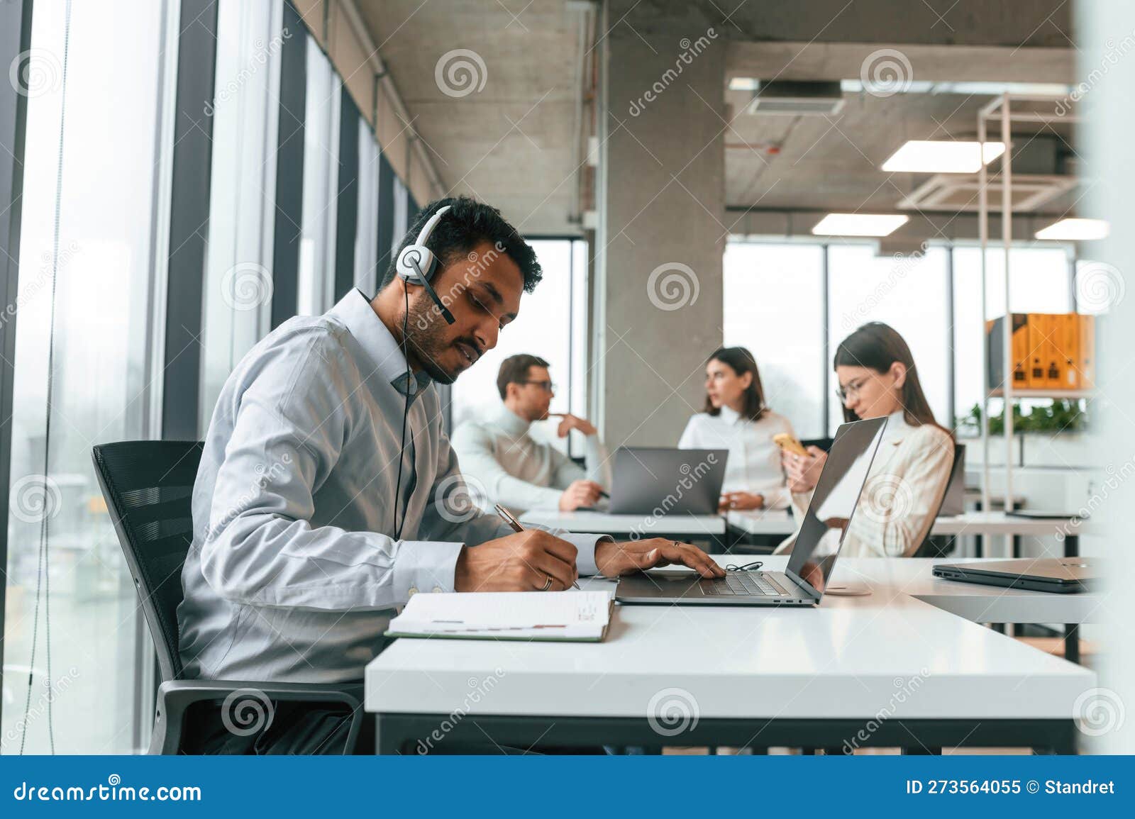 Man is Sitting in Front of His Colleagues. Four People are Working in ...
