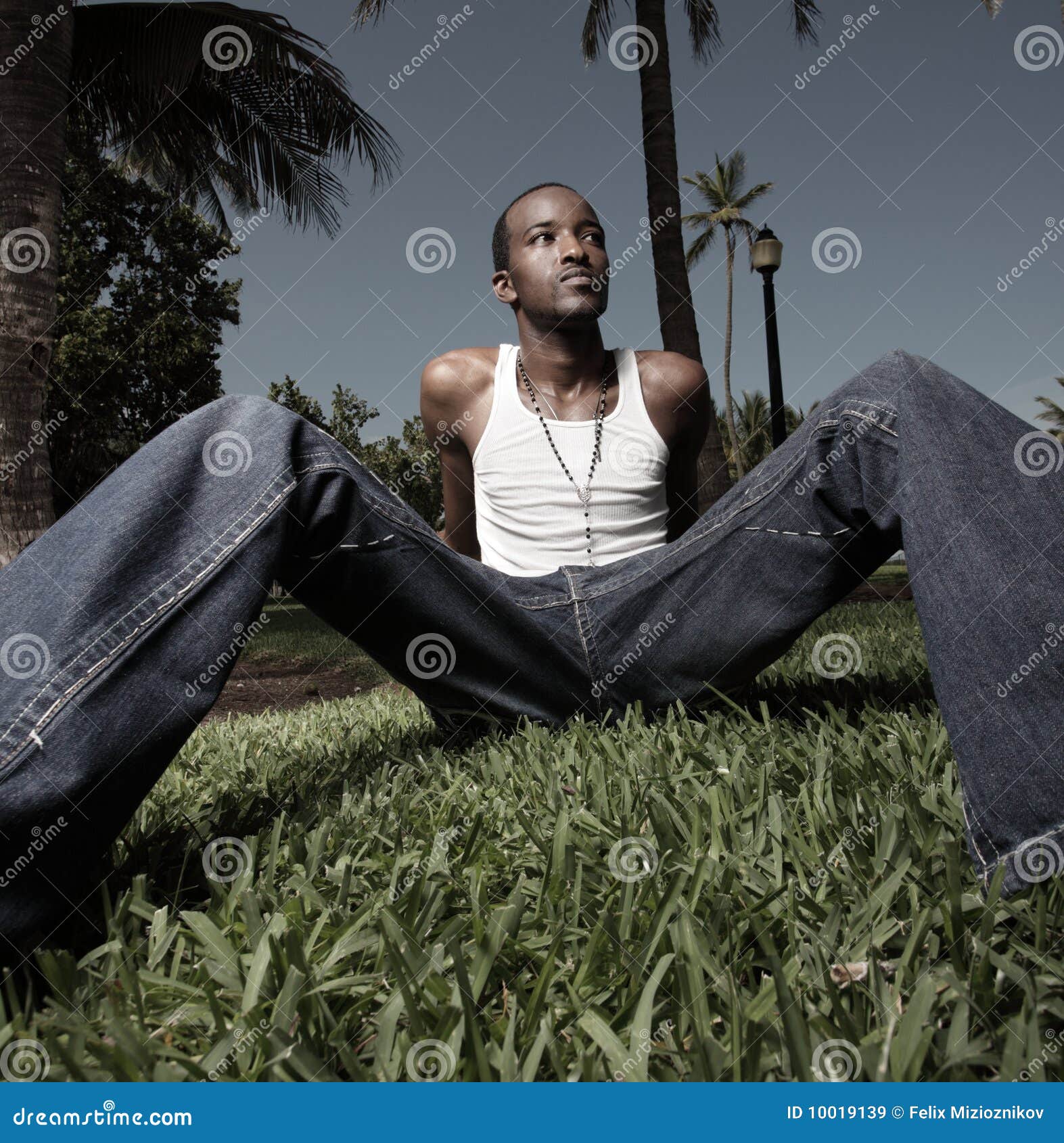 Man sitting on the grass stock image. Image of sitting - 10019139