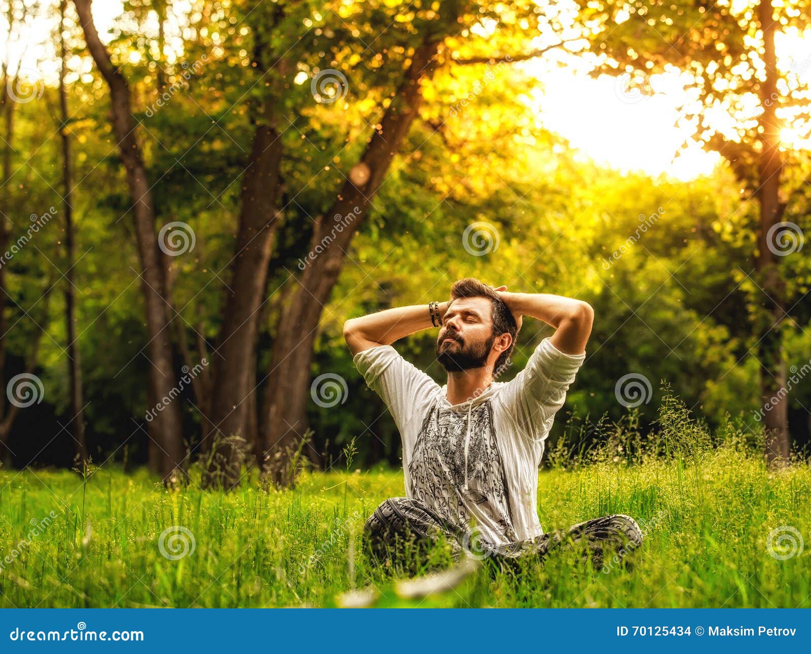 A Man Sitting on Grass in the Park and Stretching Stock Photo - Image ...