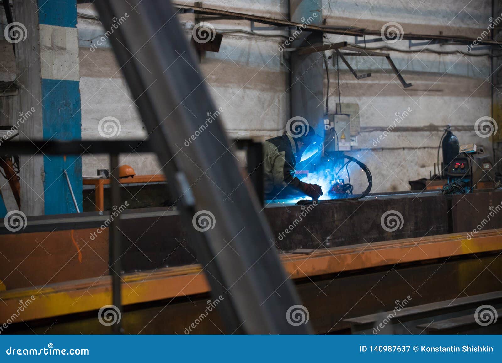A Man Sitting at His Workplace and Using a Welding Machine Stock Image ...