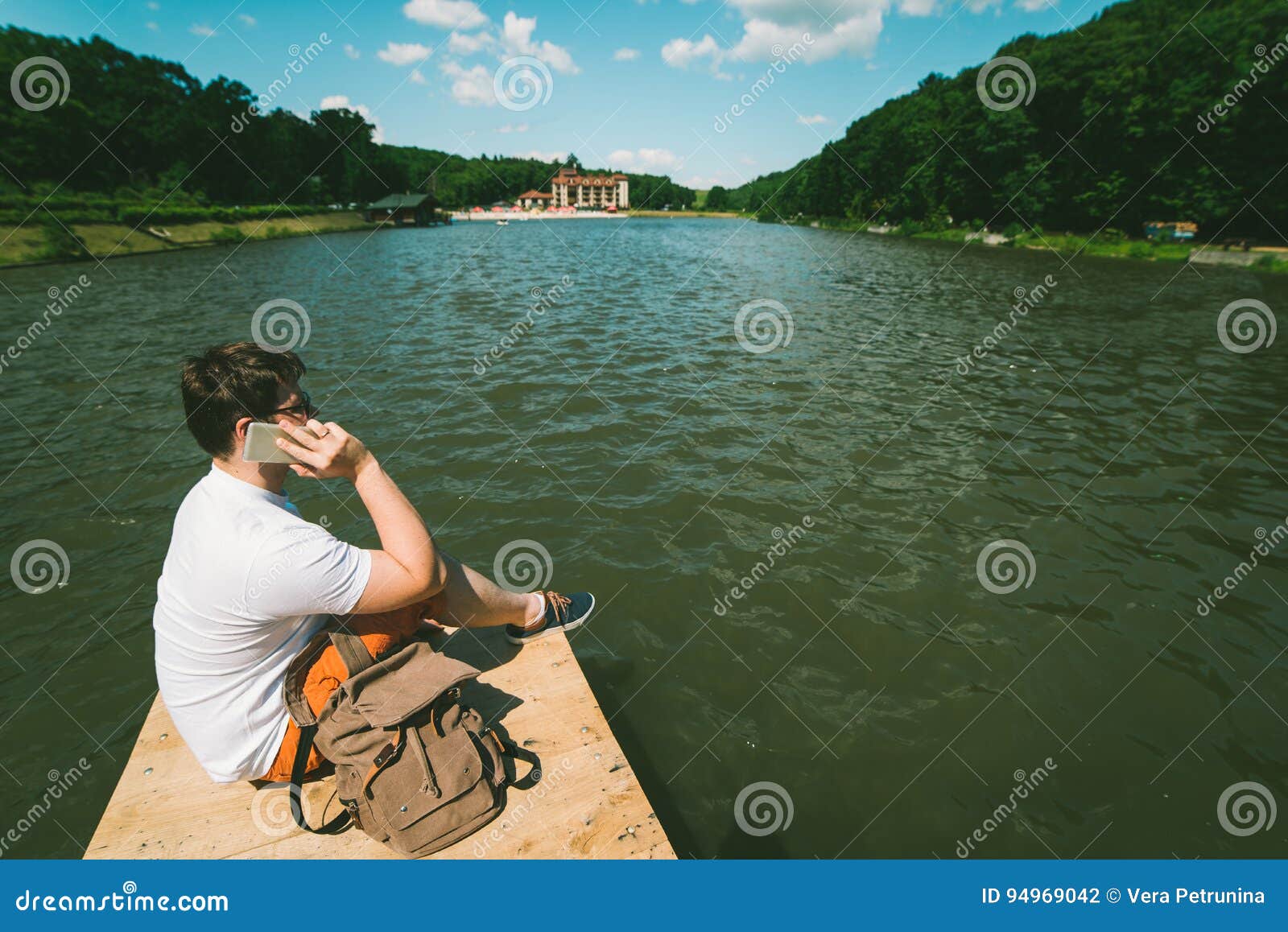 Man sitting on a lake pier stock photo. Image of holiday - 94969042