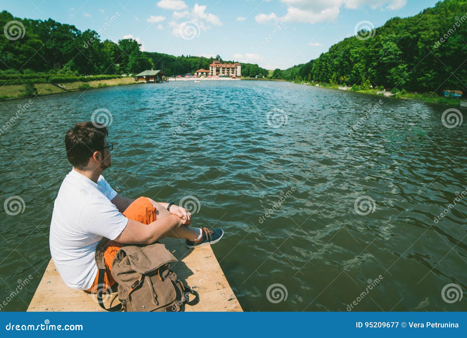 Man sitting on a lake pier stock image. Image of dock - 95209677