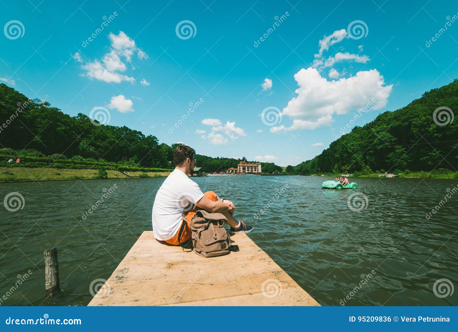 Man sitting on a lake pier stock photo. Image of relaxation - 95209836