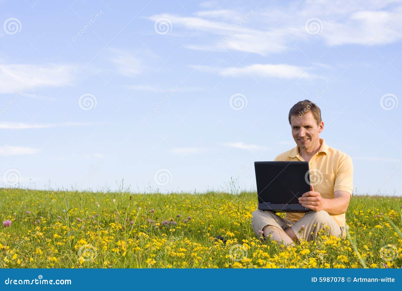 Man Sitting with Laptop Computer in a Meadow Stock Photo - Image of ...