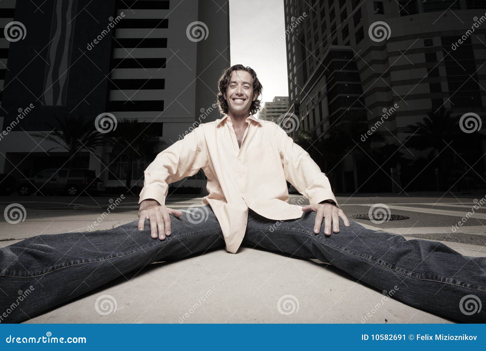 Man Sitting with Legs Extended Stock Image - Image of smiling, angle ...