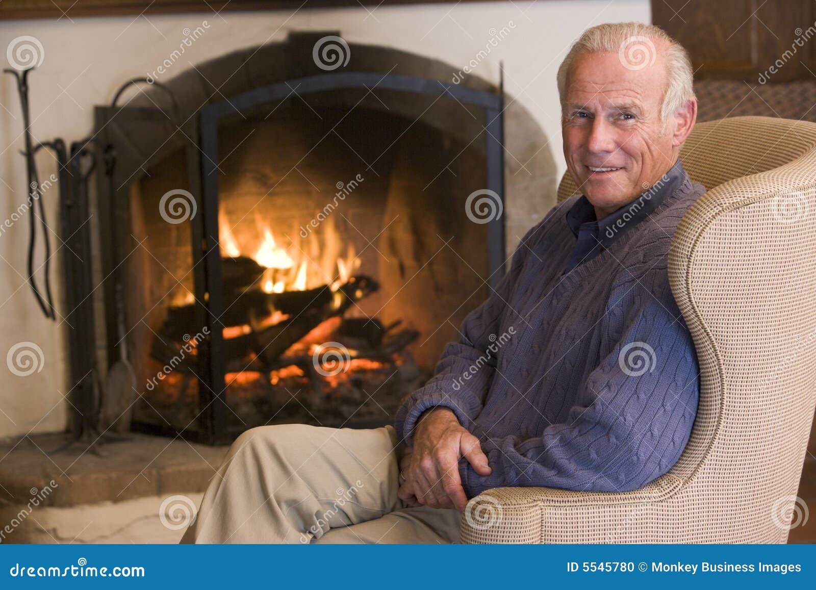 Man Sitting in Living Room by Fireplace Smiling Stock Photo - Image of ...