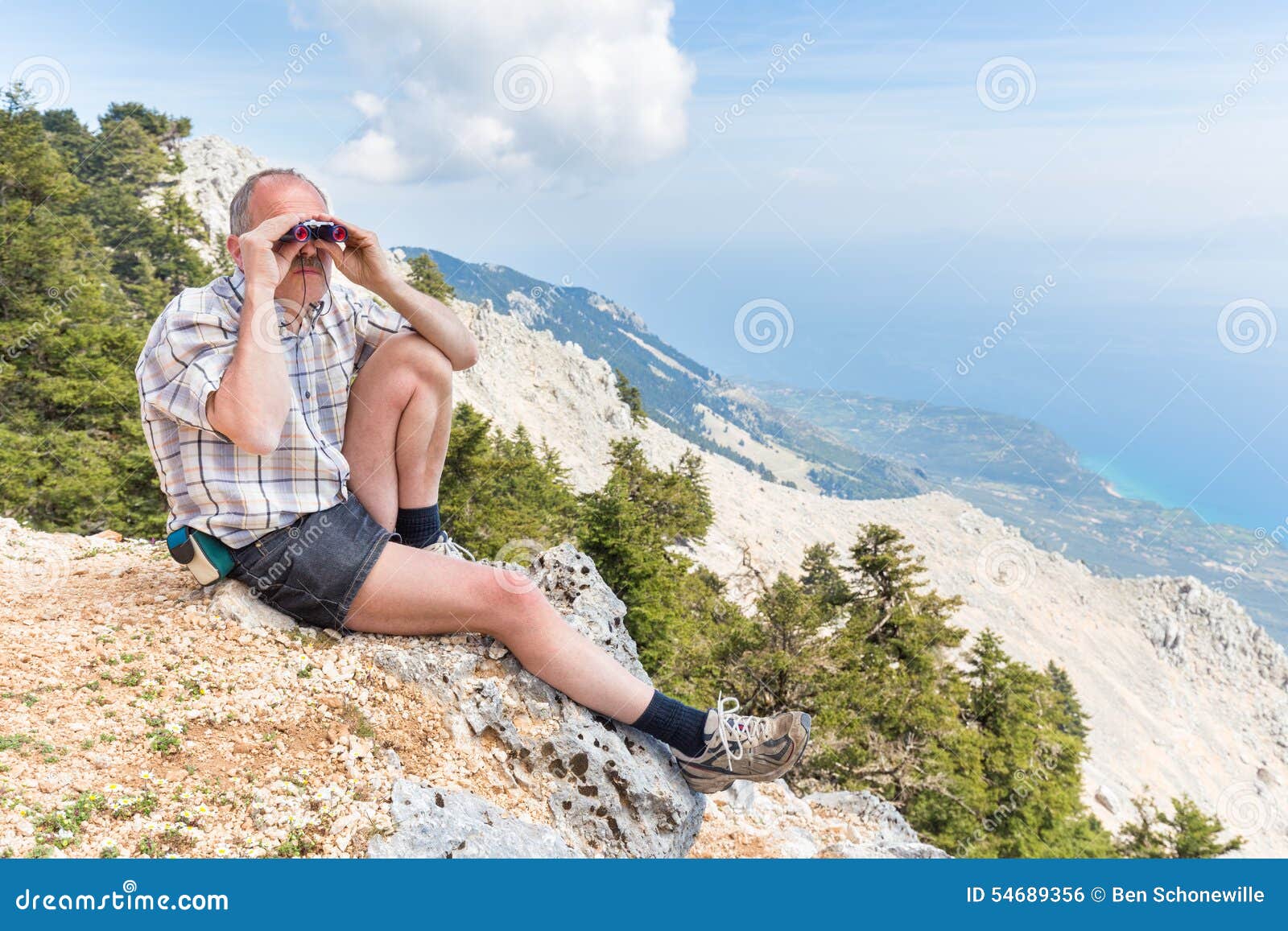 Man Sitting in Mountains Looking through Binoculars Stock Photo - Image ...