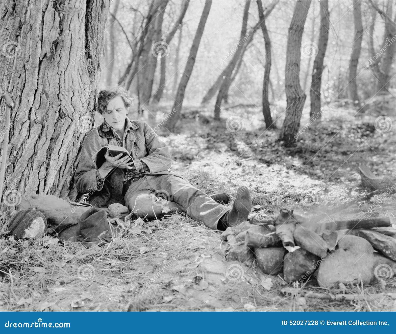 Man Sitting Next To a Fire in the Woods and Reading a Book Stock Photo ...