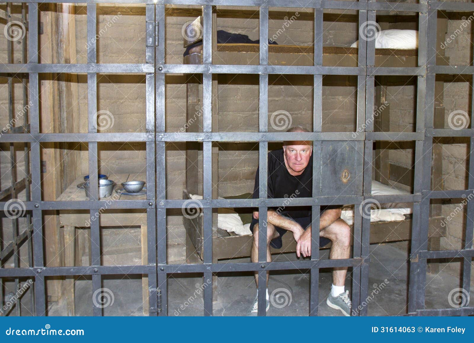 Man Sitting in Old Time Jail Stock Image - Image of southwestern ...