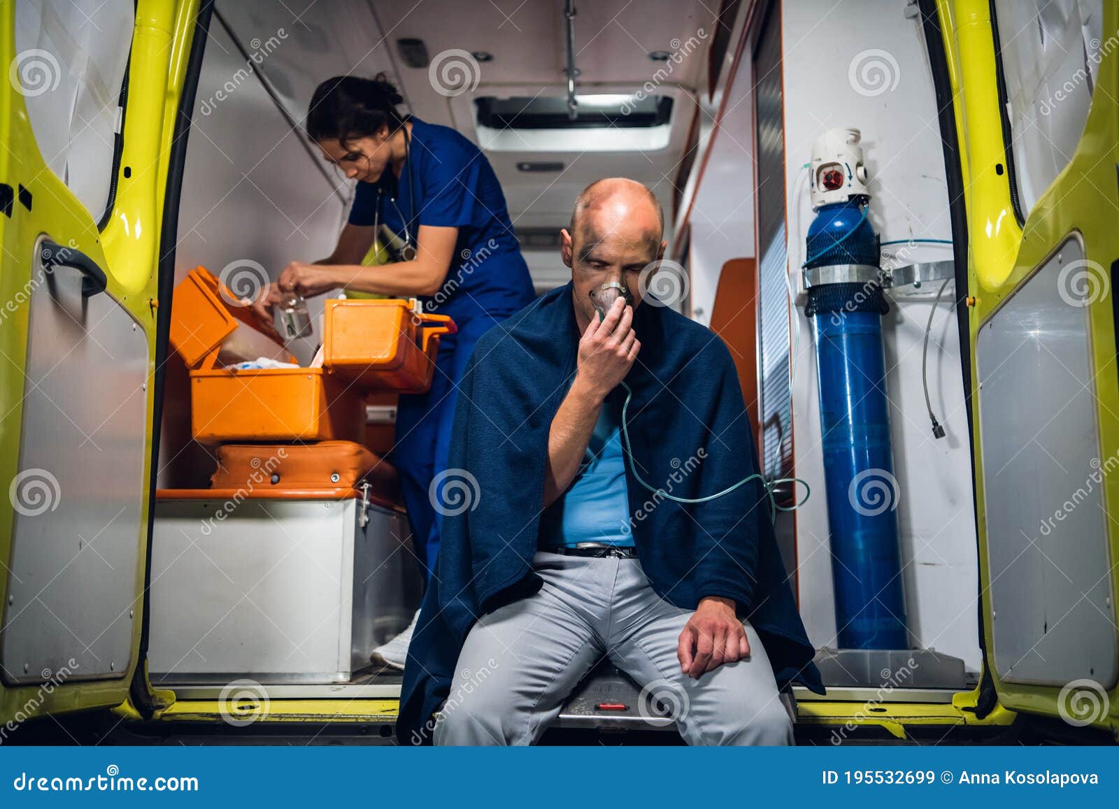 Man Sitting With An Oxygen Mask In An Ambulance Car A Nurse Looking