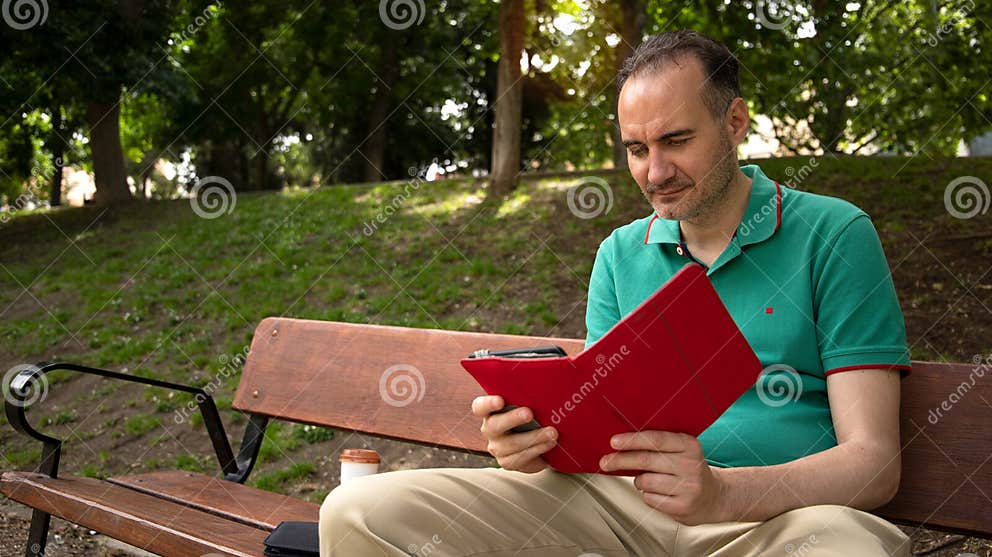 Man Sitting in the Park Reading with Tablet Stock Image - Image of ...