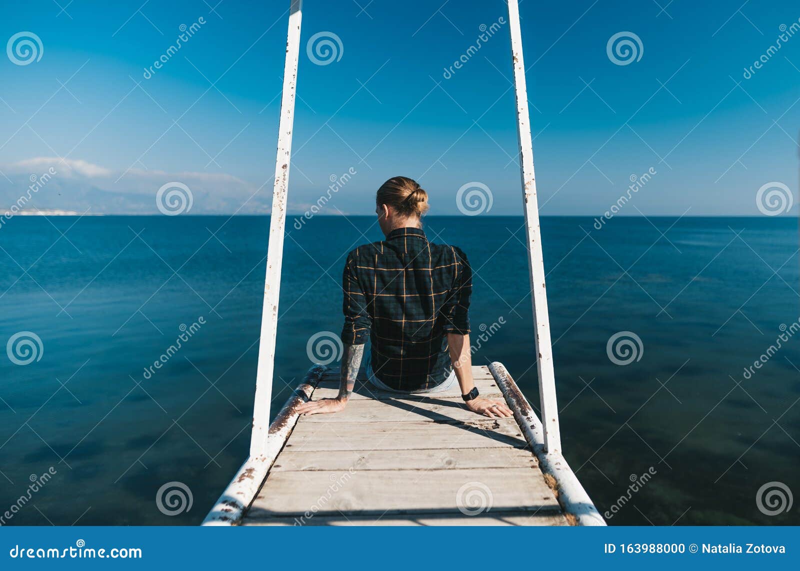 Man is Sitting on the Pier Looking at the Lake Stock Photo - Image of ...