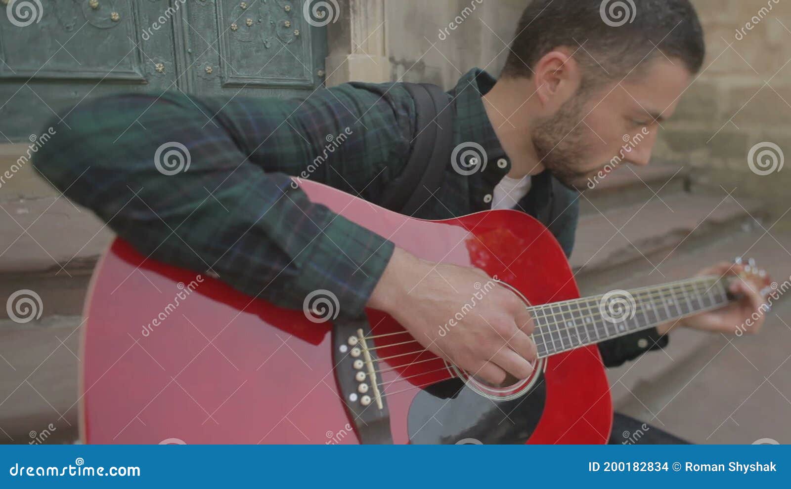 Man Sitting on the Platform of a Train Station and Singing and Playing ...