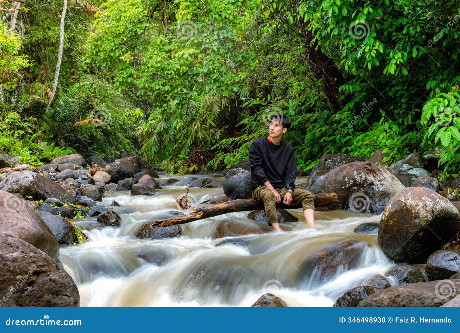 Man Sitting on the River while Looking Around. Young Man Sitting Alone ...