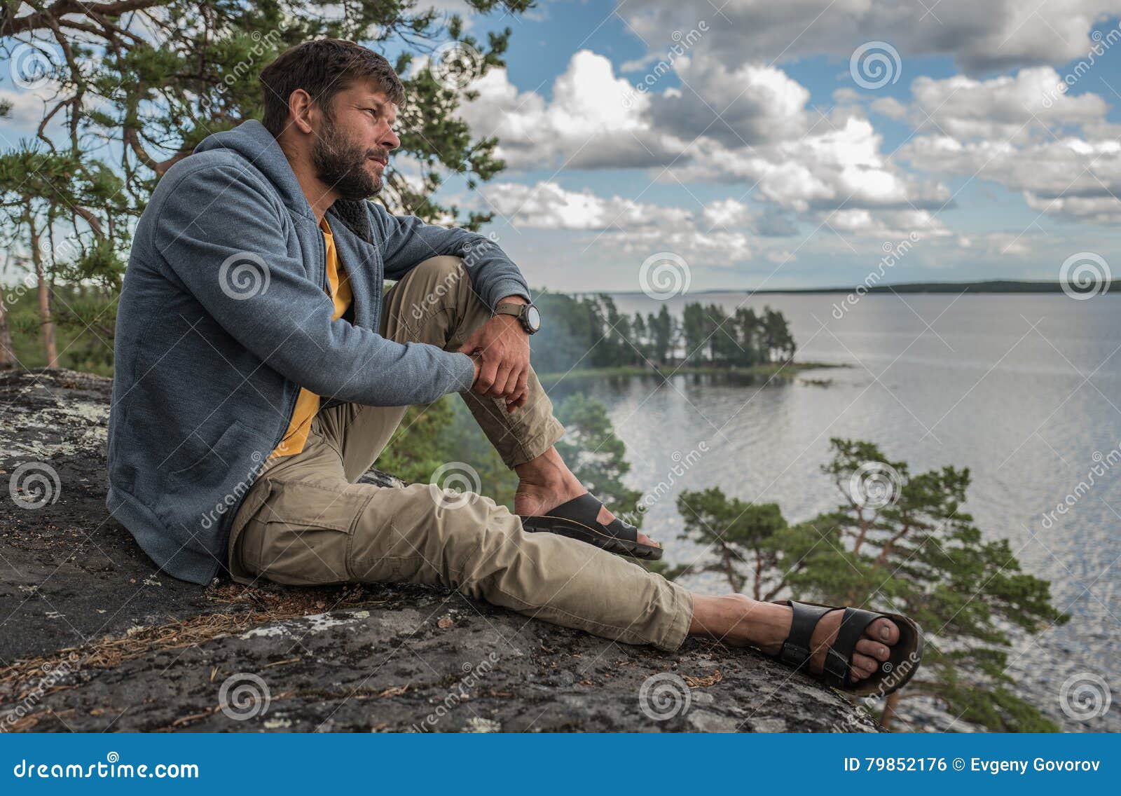 Man is Sitting on the Rock and Looking into the Distance Stock Photo ...