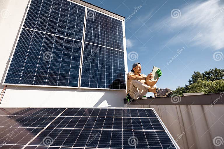 Man Sitting on a Rooftop with Solar Panels and Using Digital Tablet ... Man Sitting on a Rooftop with Solar Panels and Using Digital Tablet ...