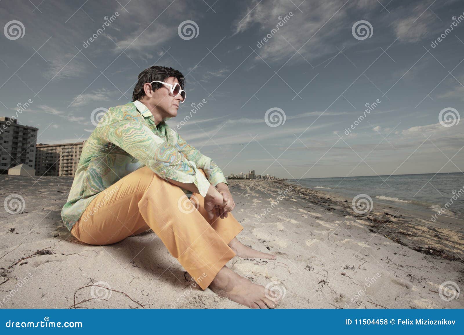 Man sitting on the sand stock photo. Image of orange - 11504458