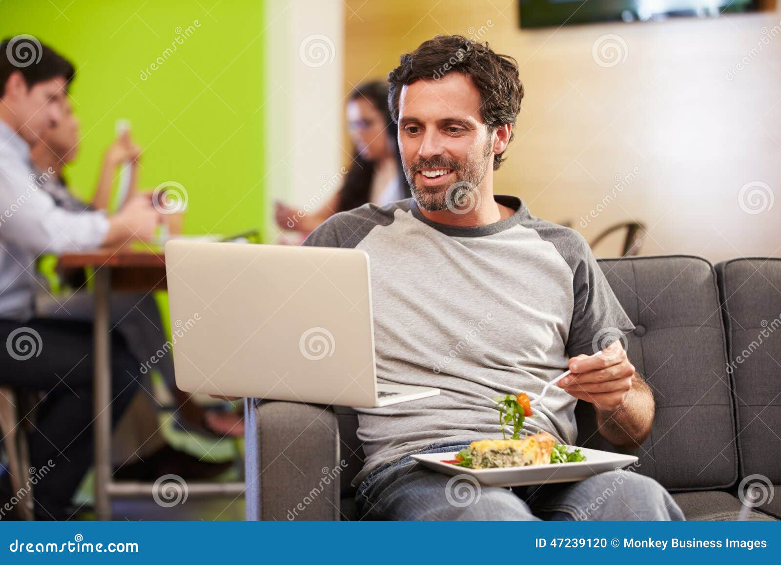 Man Sitting on Sofa and Eating Lunch in Design Studio Stock Photo ...