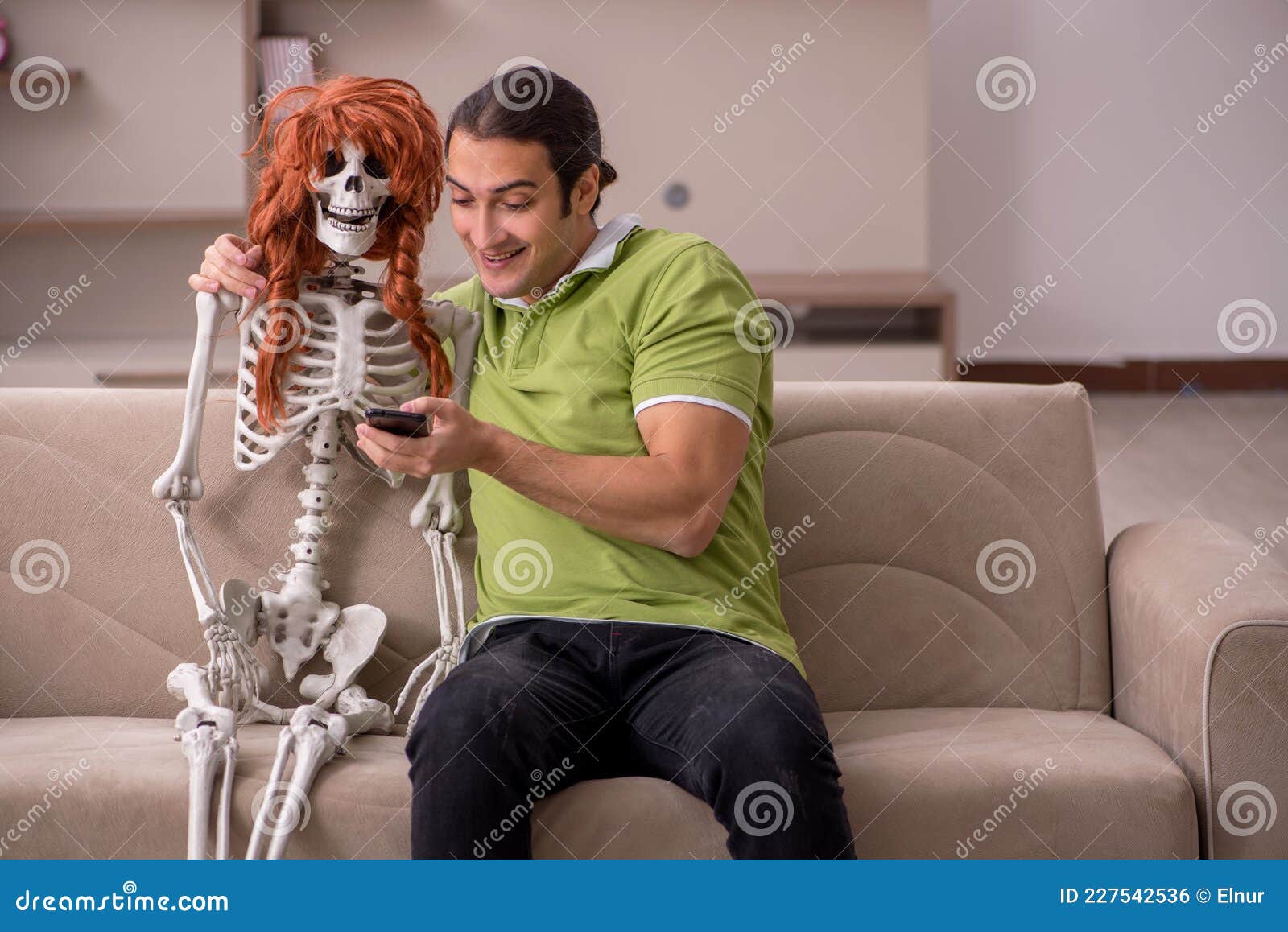 Young Man Sitting on the Sofa with Female Skeleton Stock Photo - Image ...