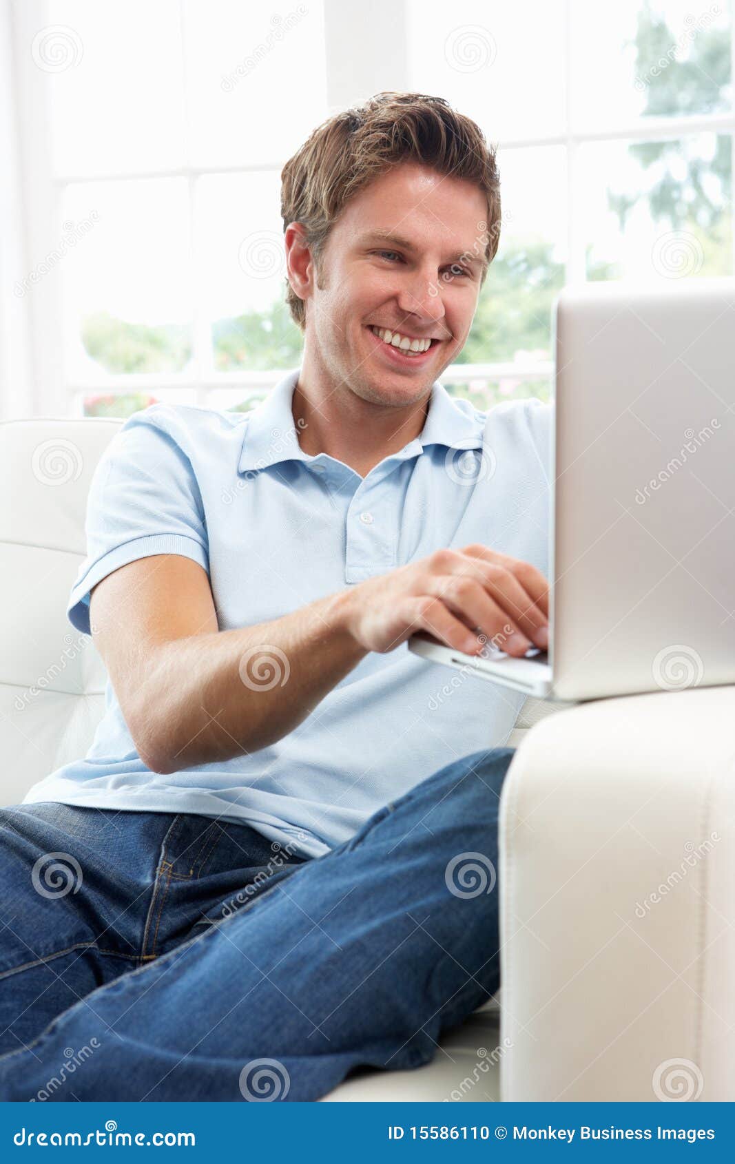 Man Sitting on Sofa Using Laptop at Home Stock Photo - Image of working ...