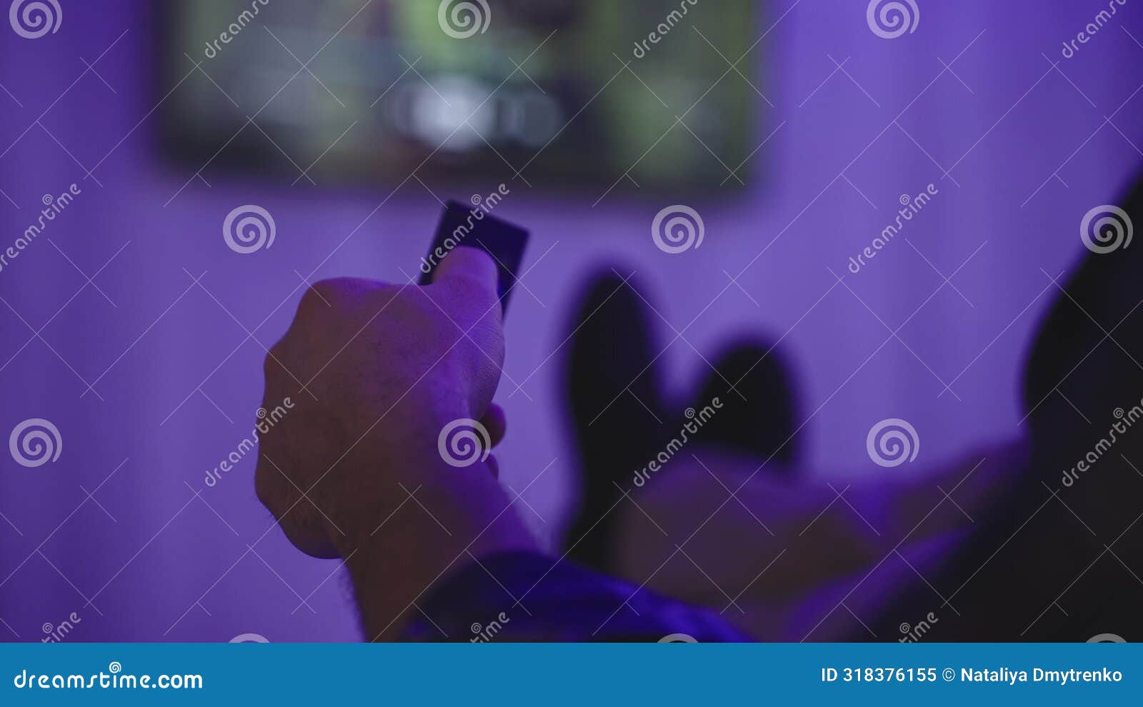 Man Sitting on Sofa and Watching TV with Remote Controller in His Hand ...