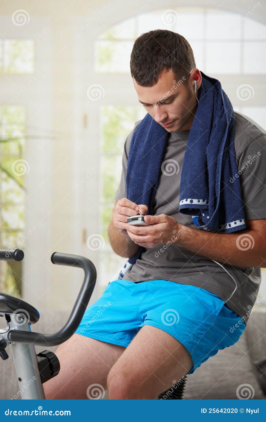 Man Sitting on Stationary Bike Stock Photo - Image of exercise, cell ...