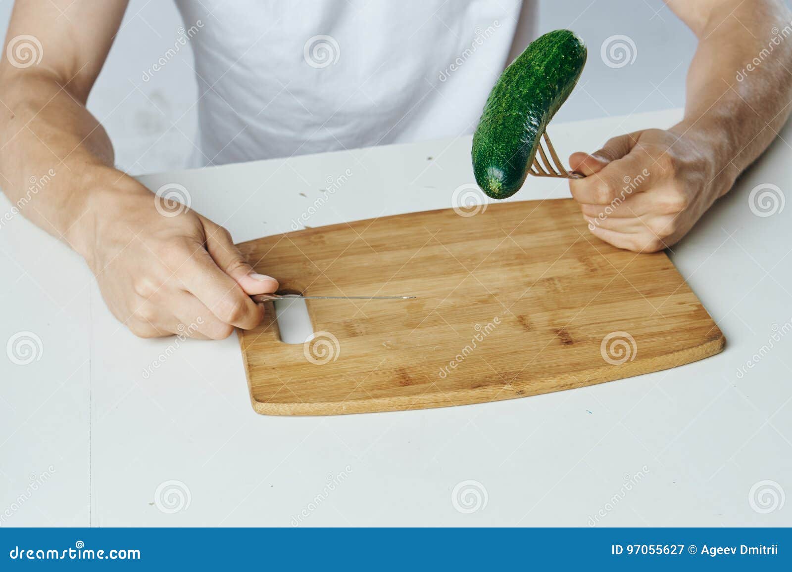 Man Sitting at a Table, Cucumber on a Cutting Board, White Background ...