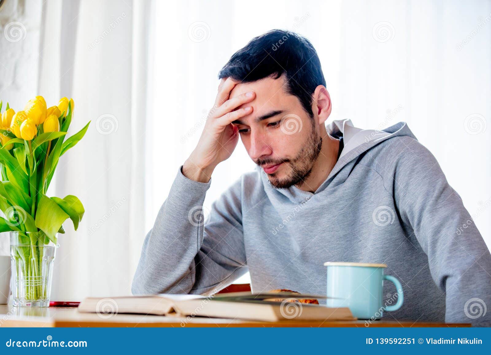 Man Sitting at Table with Cup of Coffee or Tea and Book. Stock Image ...