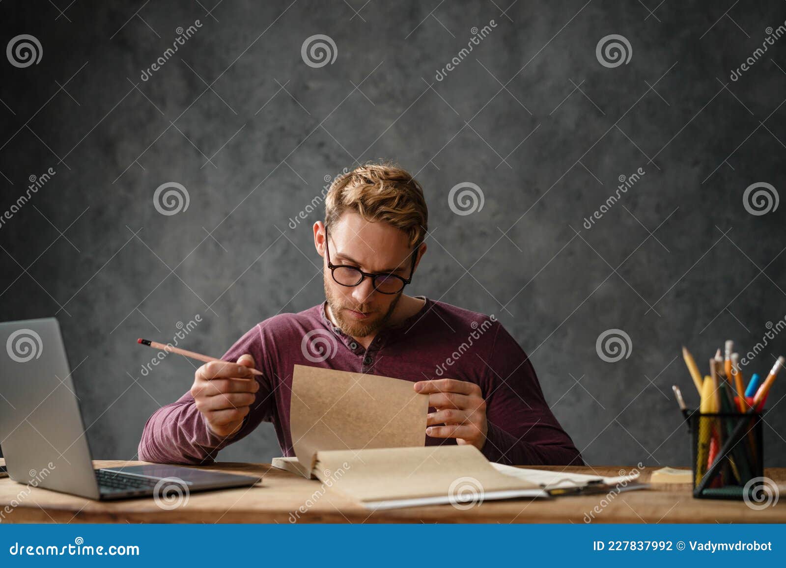 The Man Sitting at the Table while Flipping through Papers in the ...