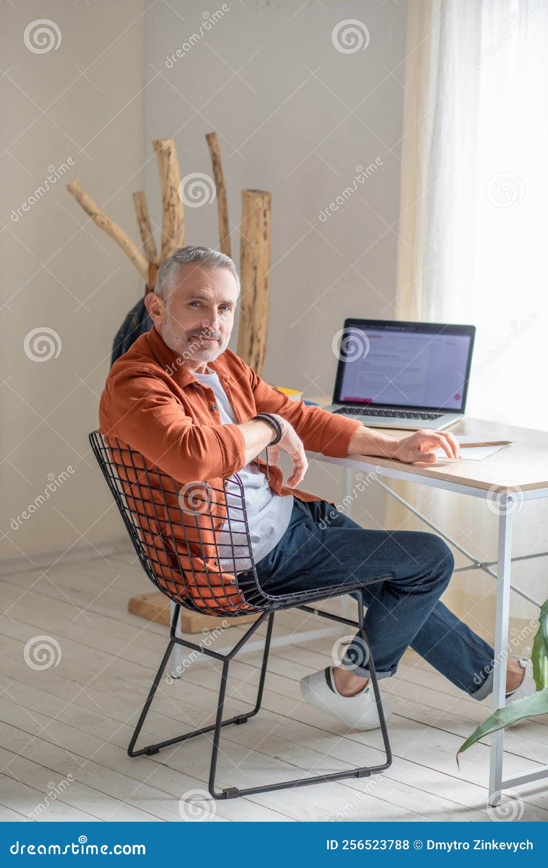 A Man Sitting at the Table in the Offcie and Looking Contented Stock ...