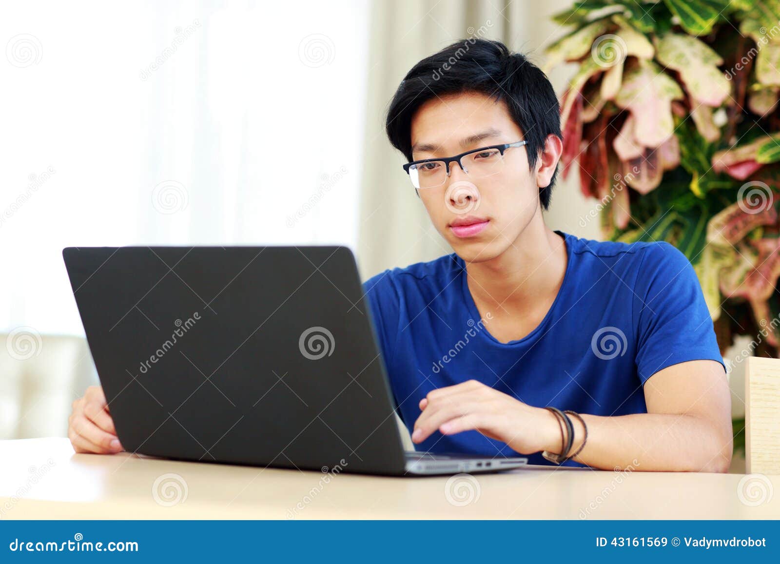 Man Sitting at the Table and Using Laptop Stock Image - Image of room ...