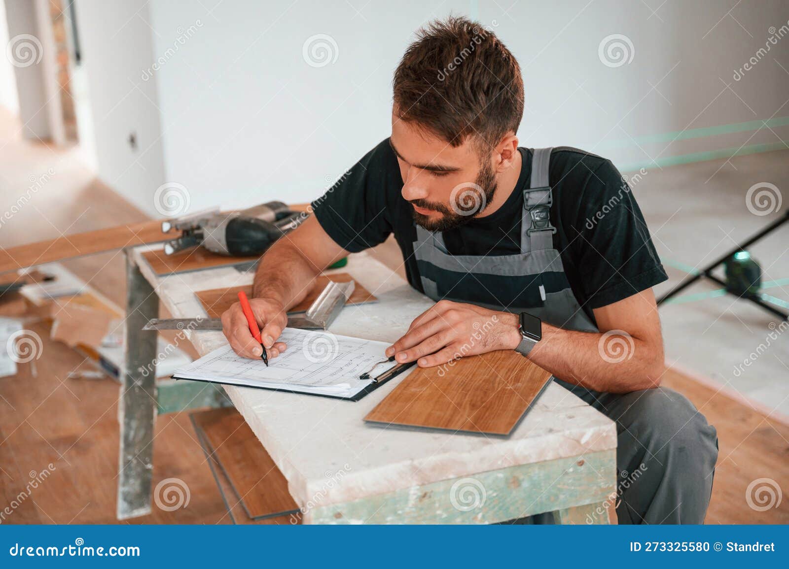 Man Sitting by the Table and Writing Data into Notebook. with New ...