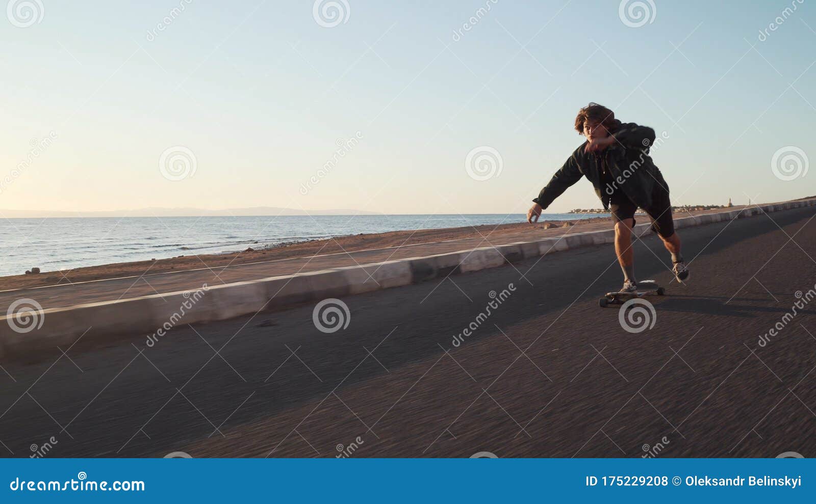 Man Skateboarding on Boulevard Along the Ocean at Golden Light. Stock ...