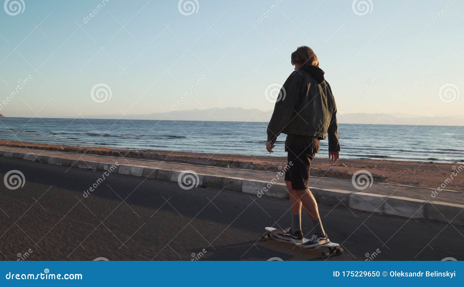 Man Skateboarding on Boulevard Along the Ocean at Golden Light. Stock ...