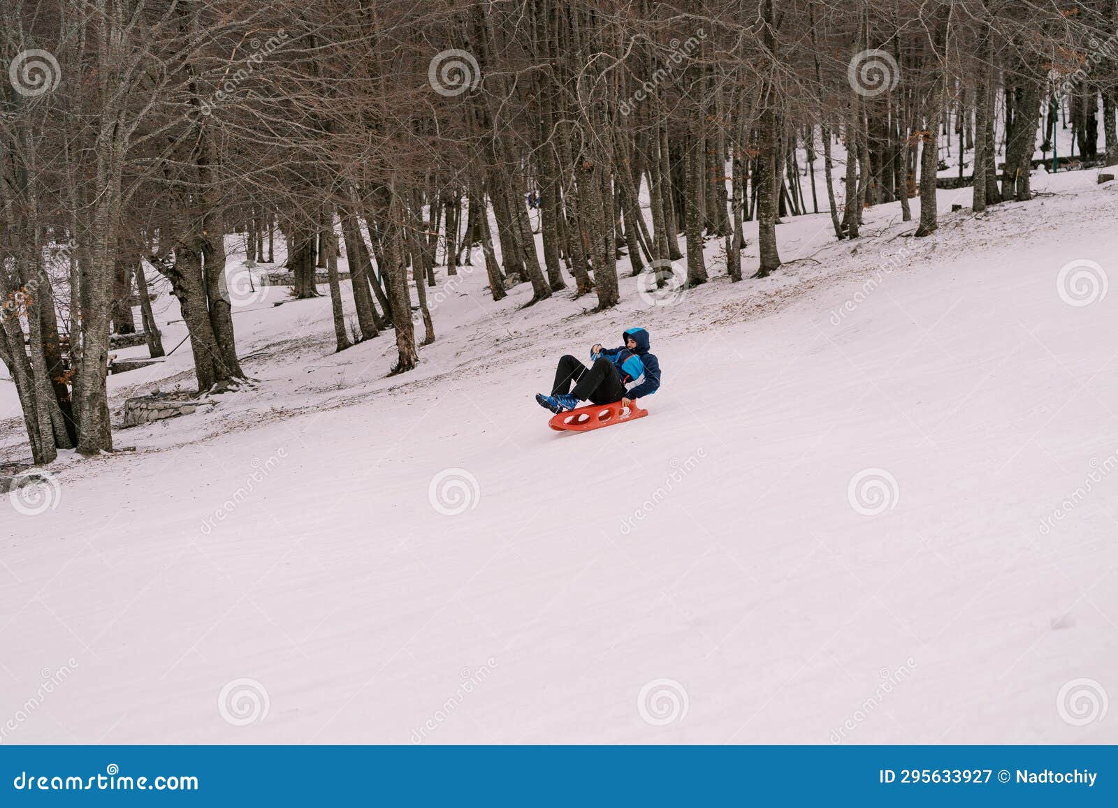 Man Sledding Down a Hill Lying on His Back Stock Image - Image of slide ...
