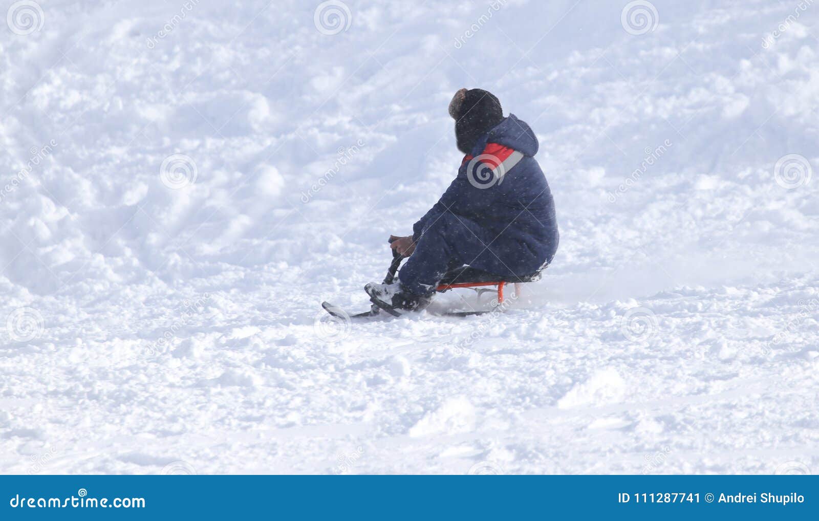 Man sledding in the snow stock image. Image of alone - 111287741