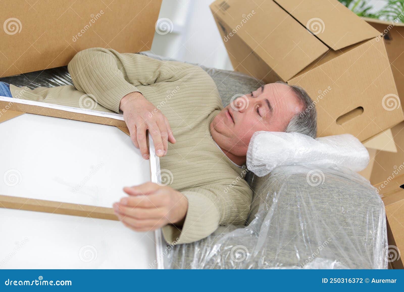 Man Sleeping in between Boxes Stock Photo - Image of floor, order ...