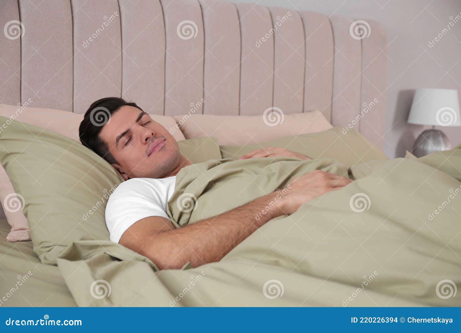 Man Sleeping in Comfortable Bed with Green Linens Stock Photo - Image ...