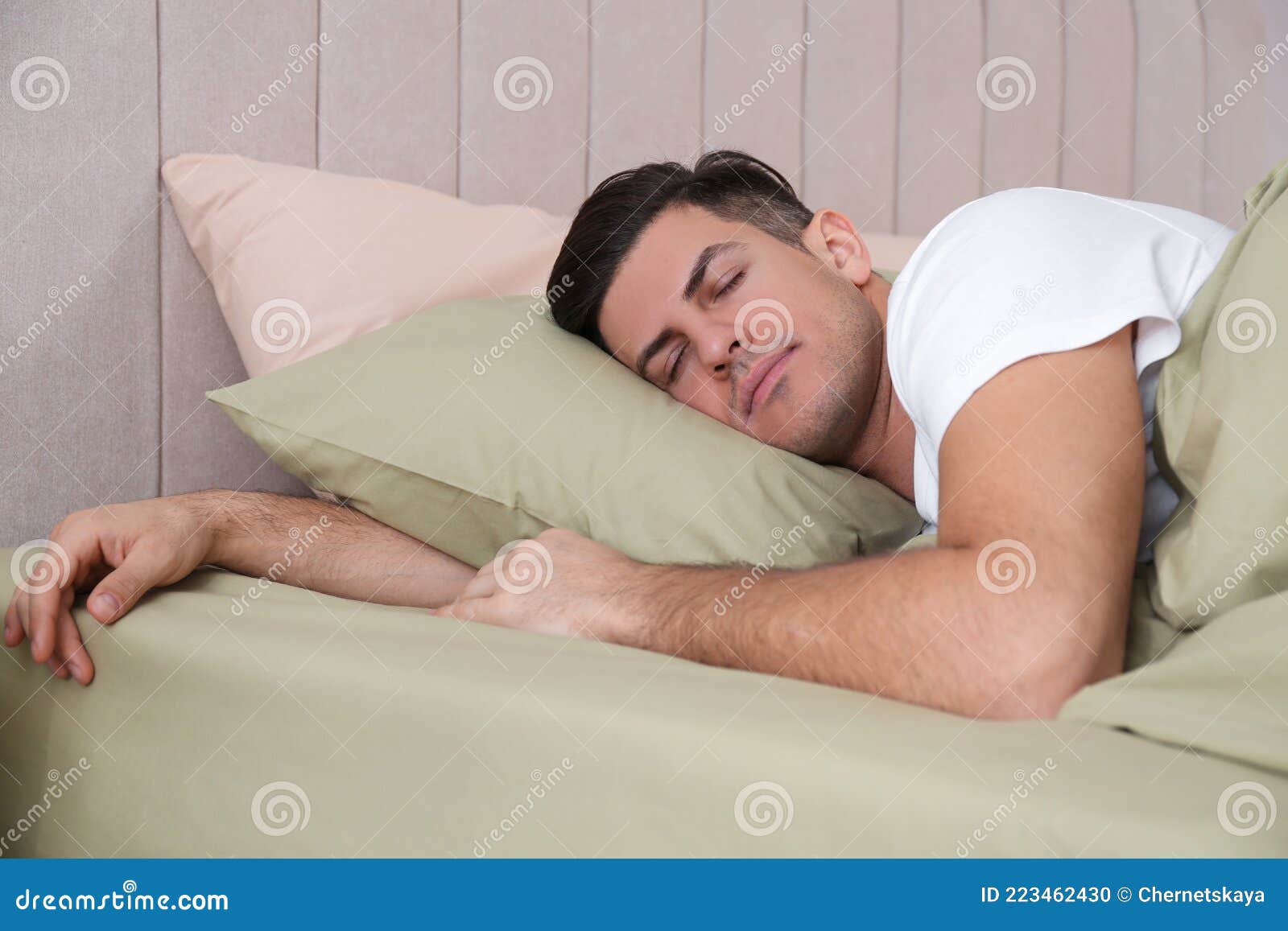Man Sleeping in Comfortable Bed with Green Linens Stock Photo - Image ...