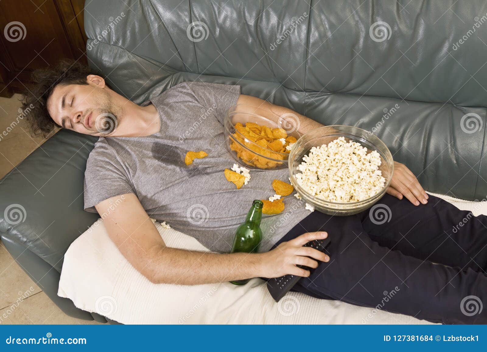 Tired Young Man Sleeping on a Sofa with Food after Party Stock Photo ... Tired Young Man Sleeping on a Sofa with Food after Party Stock Photo ...