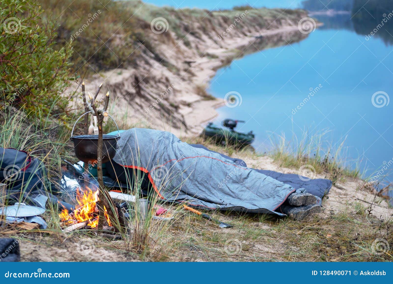 A Man is Sleeping Next To a Fire at the Beach Dunes. Stock Image ...