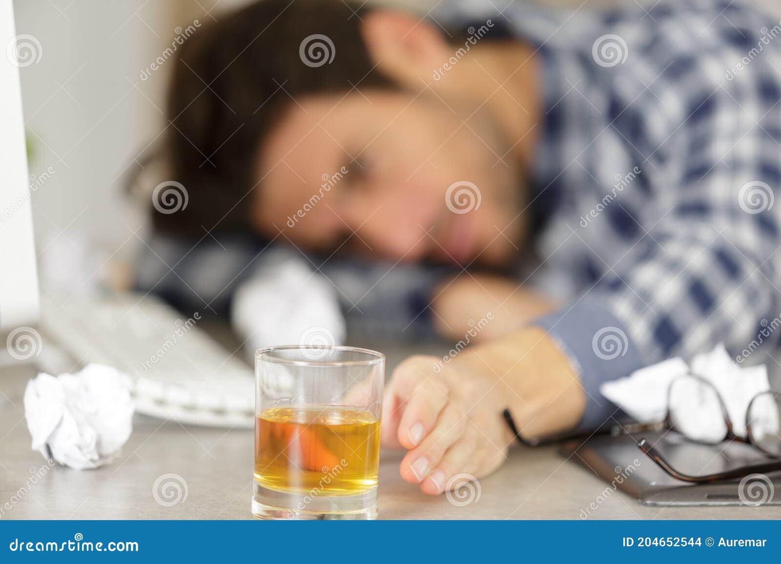 Man Slumped Across Desk Reaching for Alcoholic Drink Stock Photo ...