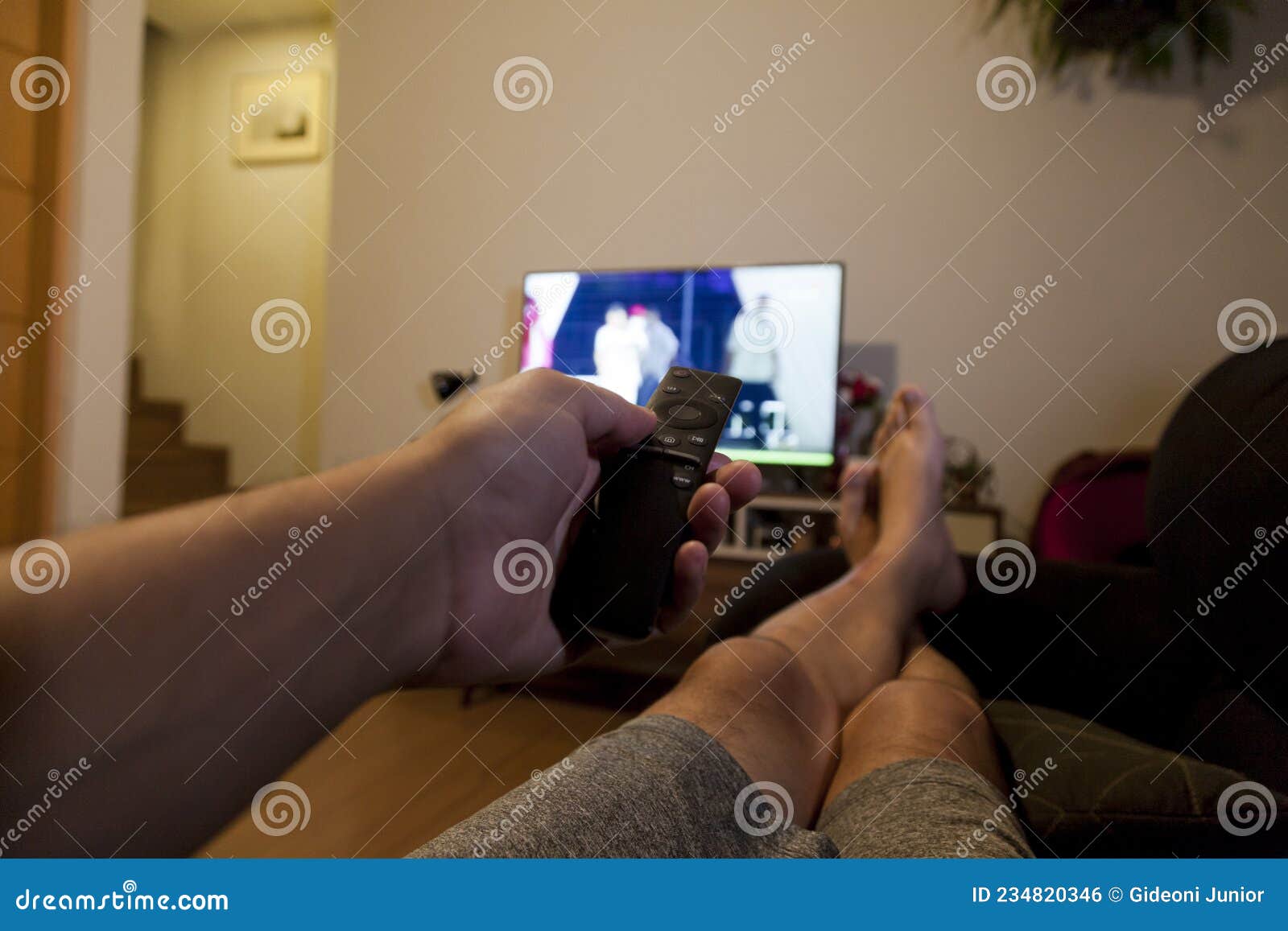 Man with Smart TV Remote Control in Hand, Changing Channel and Watching ...