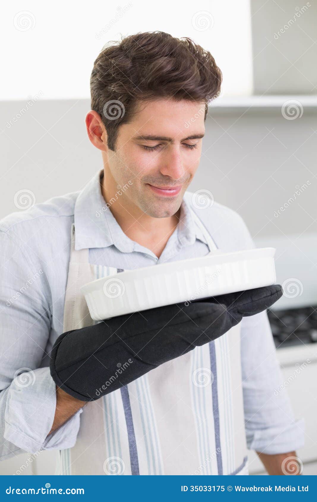 Man Smelling Food in Baking Dish in Kitchen Stock Image - Image of ...