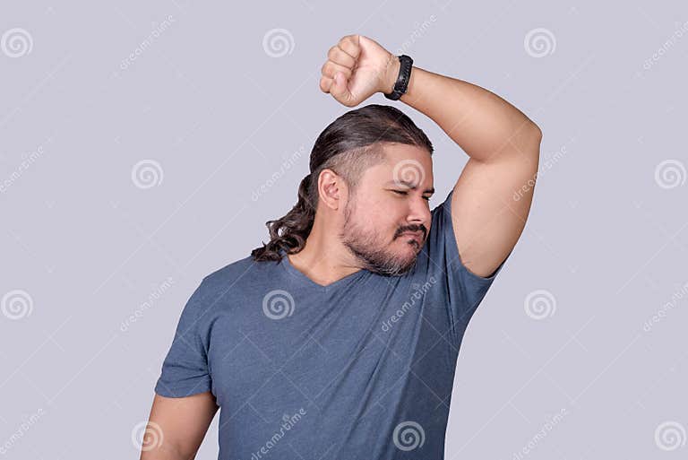 A Man Smells His Underarm Through His Shirt Checking For Signs Of Body Odor From His Armpit 7693
